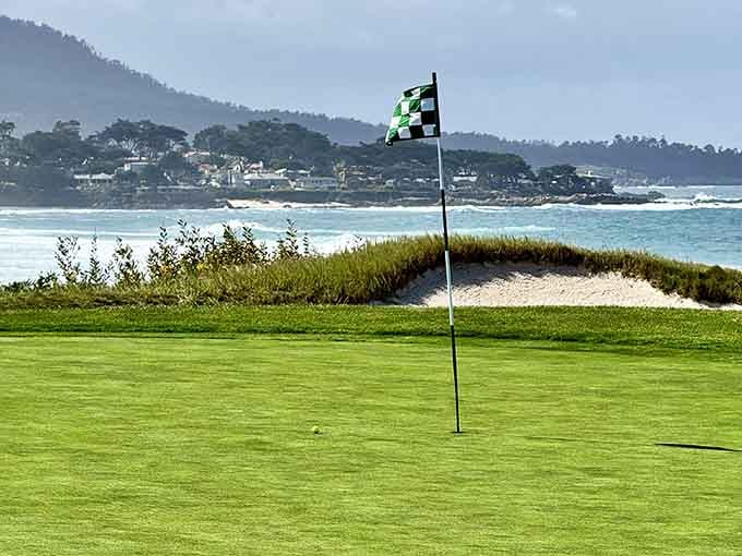 The flag waves hello while the ocean whispers that your ball might be visiting soon, like it or not.