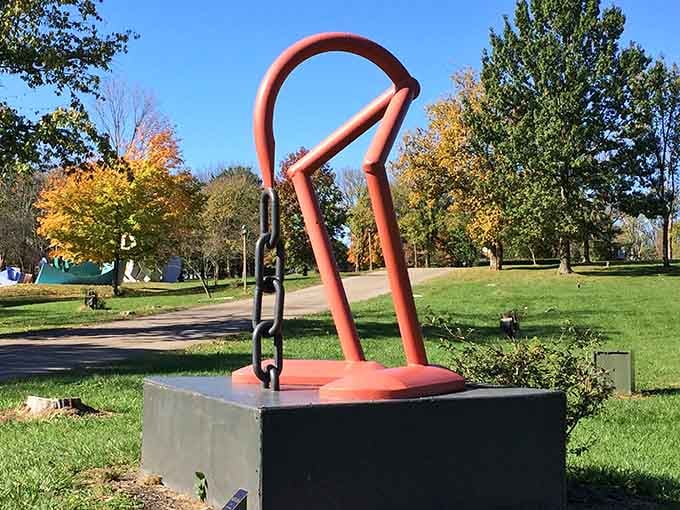 Coral-colored curves rise from concrete like a safety pin reimagined by someone with serious artistic ambitions.