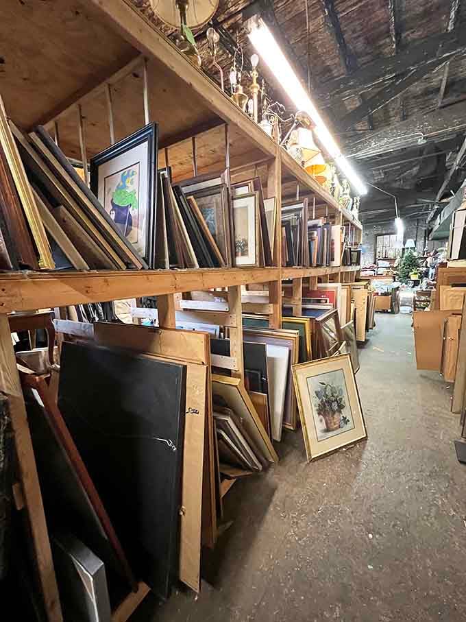 Framed artwork leaning against shelves, waiting for someone to finally give them the wall space they deserve again.