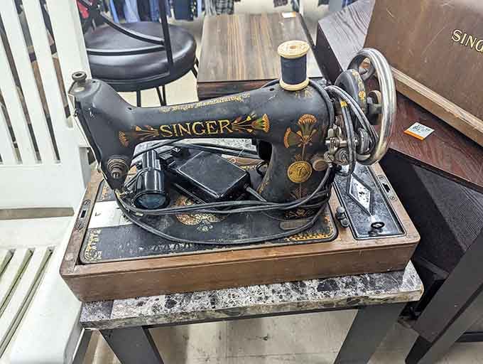 A vintage Singer sewing machine that's seen more fabric than a fashion designer's entire career, still ready to stitch.