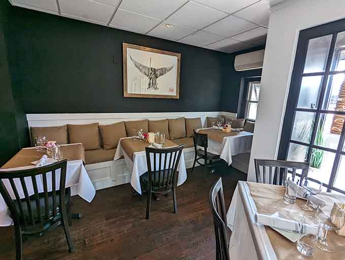 Cozy booth seating with deep green walls creates the kind of intimate dining space where good conversations happen naturally over great food.