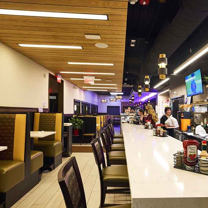 Counter seating with modern touches and purple accent lighting creates an unexpectedly stylish dining experience for solo visitors.