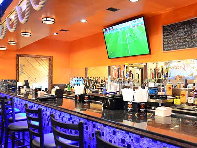 The bar area glows with orange warmth, ready to serve cold drinks that pair perfectly with spicy seafood feasts.