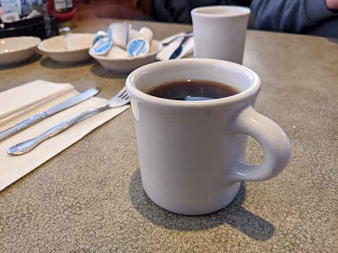 That classic diner coffee mug sitting on speckled countertop is basically the opening scene of every great breakfast story.
