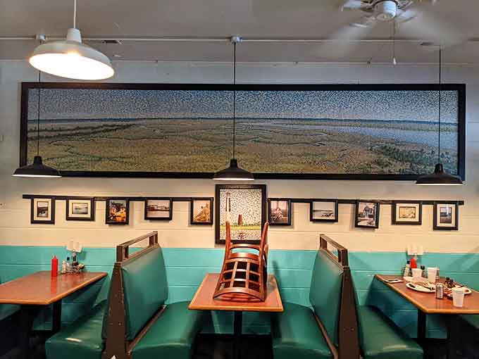 Turquoise booths beneath coastal photography that's actually from the area, not some corporate decorator's catalog.