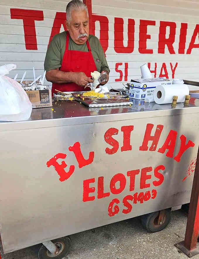 Skilled hands prepare elotes with the kind of care and precision that comes from years of practice.