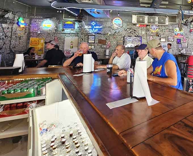 The bar where cold drinks flow and conversations happen naturally, no phones required for entertainment in this throwback space.