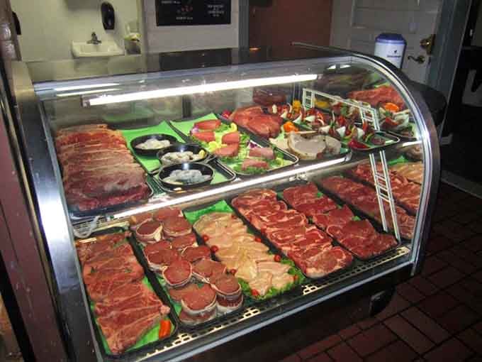 That meat display case showcases the raw materials of greatness, like an art gallery for carnivores with excellent taste.