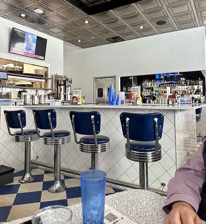 Classic diner stools at a pristine counter offer front-row seats to the breakfast theater happening behind the scenes.