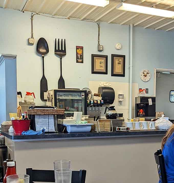 The command center where breakfast dreams are coordinated with oversized utensils keeping watch from the wall.