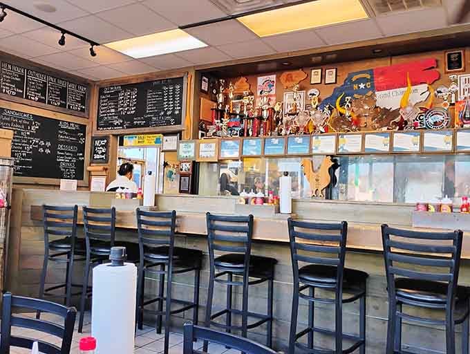 Counter seating with a trophy view, where you can admire championship hardware while waiting for championship food.