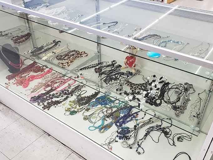 Jewelry displayed behind glass like tiny treasures waiting for their next adventure on someone's wrist or neck.