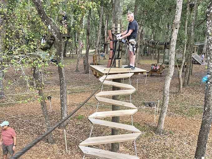 That spiral wooden walkway twists upward like something from an Escher painting, only this one requires actual physical effort to navigate.