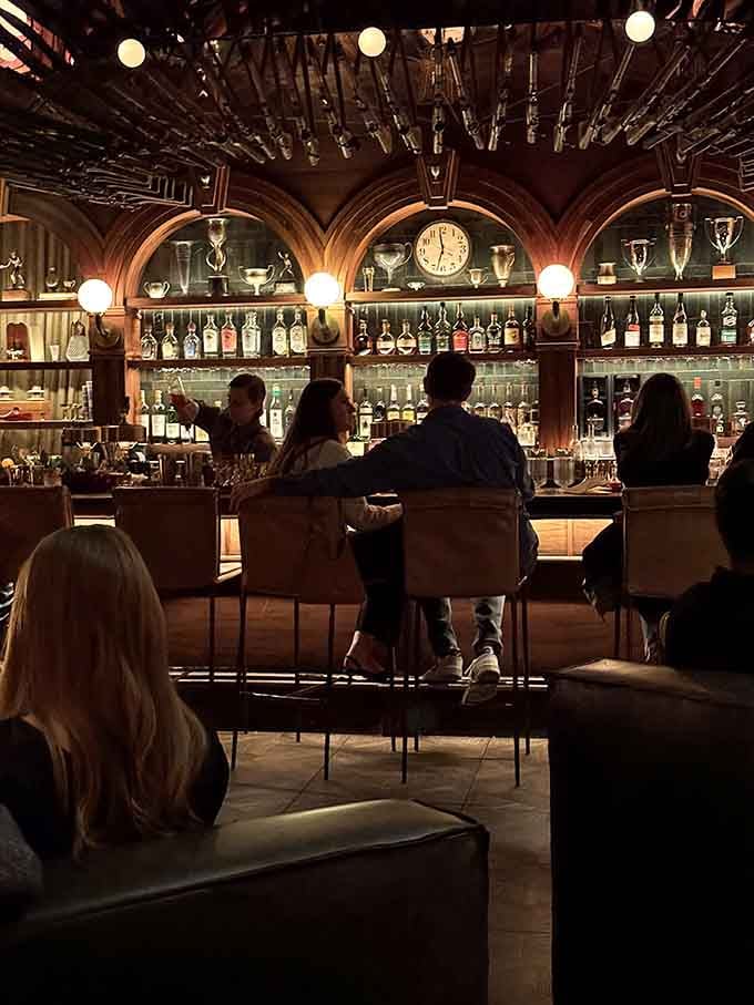 The bar beckons like a stage where mixologists perform nightly magic shows, and every seat offers front-row viewing.