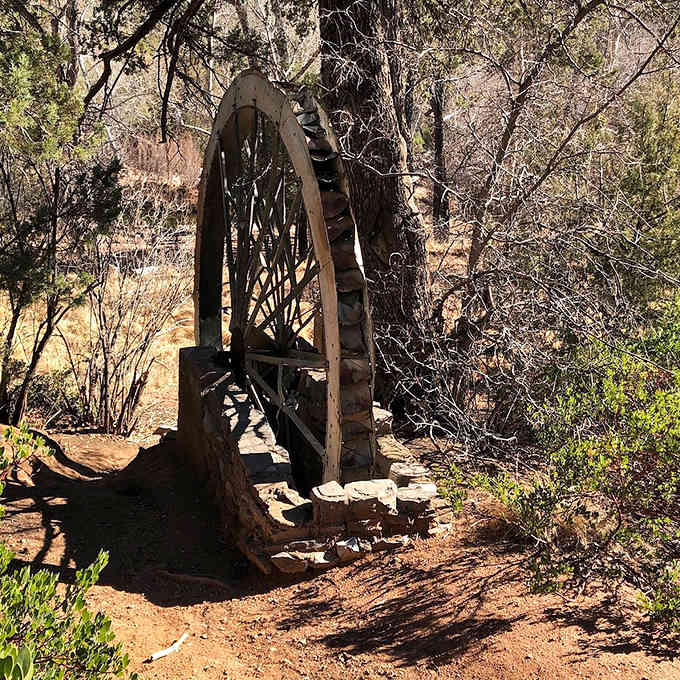 An old water wheel stands sentinel along the path, a rustic reminder of the area's hardworking mining past.