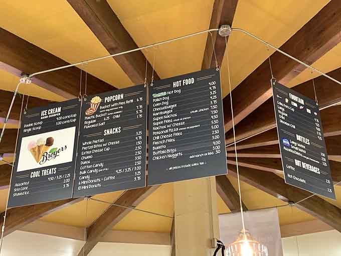Menu boards hanging overhead list classic movie snacks that haven't changed since your first date.