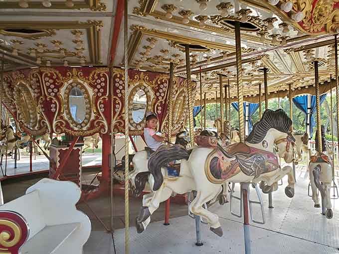 The ornate carousel horses wait patiently for their next riders beneath that gorgeous gilded ceiling.