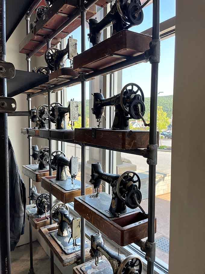 Vintage sewing machines displayed like industrial sculptures, celebrating the craftsmanship that built America's fashion industry with pride and precision.