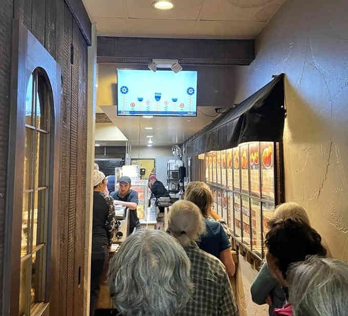 The serving line buzzes with activity as staff prepare meals with practiced precision, turning orders into delicious reality one tray at a time.
