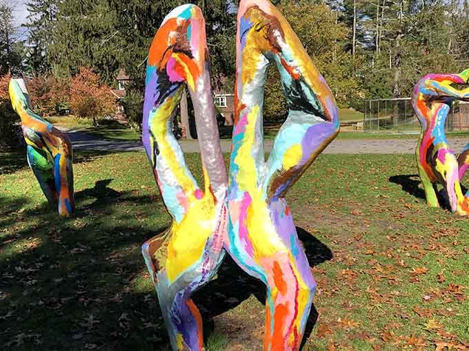 Vibrant painted figures dance across the lawn like they just heard their favorite song come on.