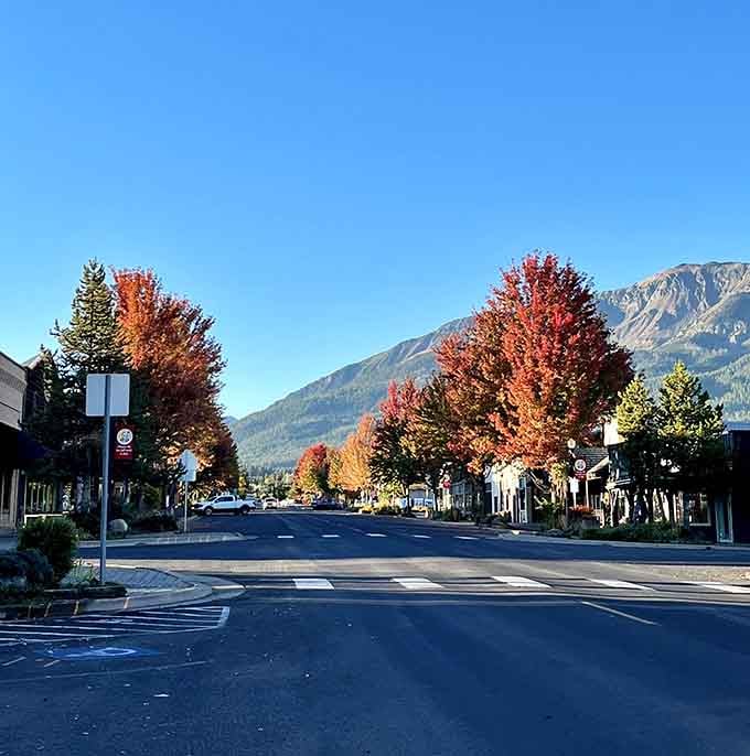 Fiery autumn trees frame the main street with mountains standing guard in the distance like nature's own welcome committee.