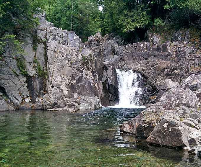 Crystal-clear water collects in a natural basin, perfect for contemplating nature's raw power and timeless beauty.