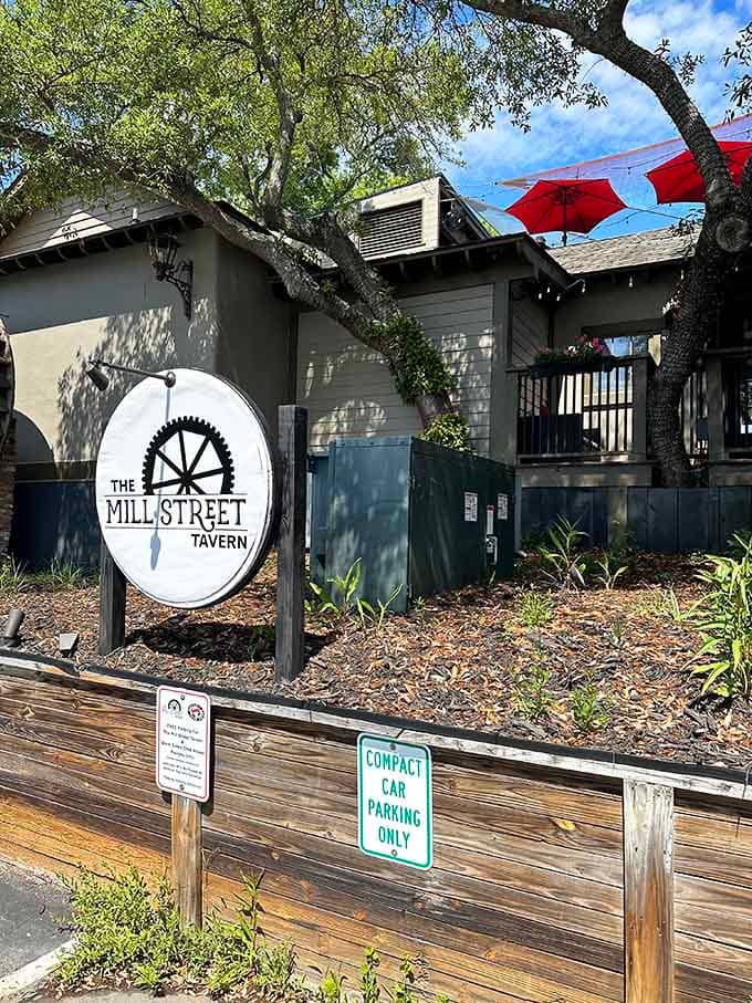 Red umbrellas pop against the natural wood deck where live oaks provide dappled shade for afternoon drinks and good conversation.