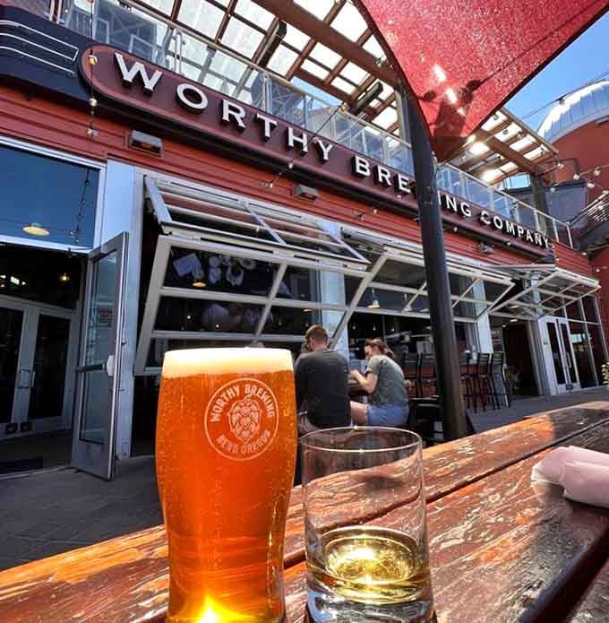 Golden beer catching sunset light while the brewery hums with life&mdash;this is exactly where you want to be.