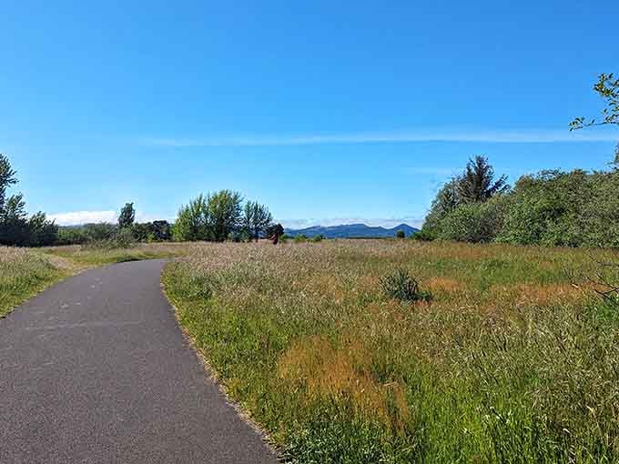 The trail stretches ahead through open grassland, offering mountain views and plenty of room to breathe deeply.