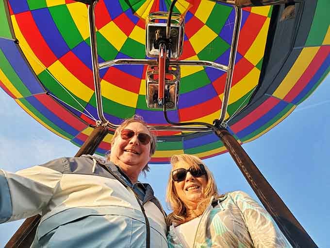 Two adventurers framed by brilliant fabric and blue sky, living their best life one peaceful drift at a time.