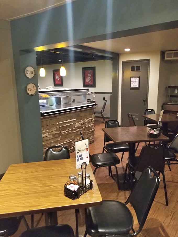 Booths and tables arranged for maximum comfort, where strangers become friends over shared pizza appreciation and cold beer.