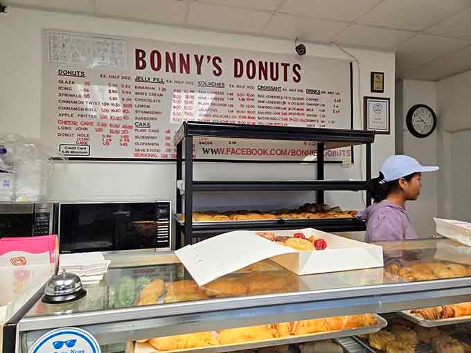 Fresh donuts cooling on racks while you wait is basically watching edible art being created in real time.