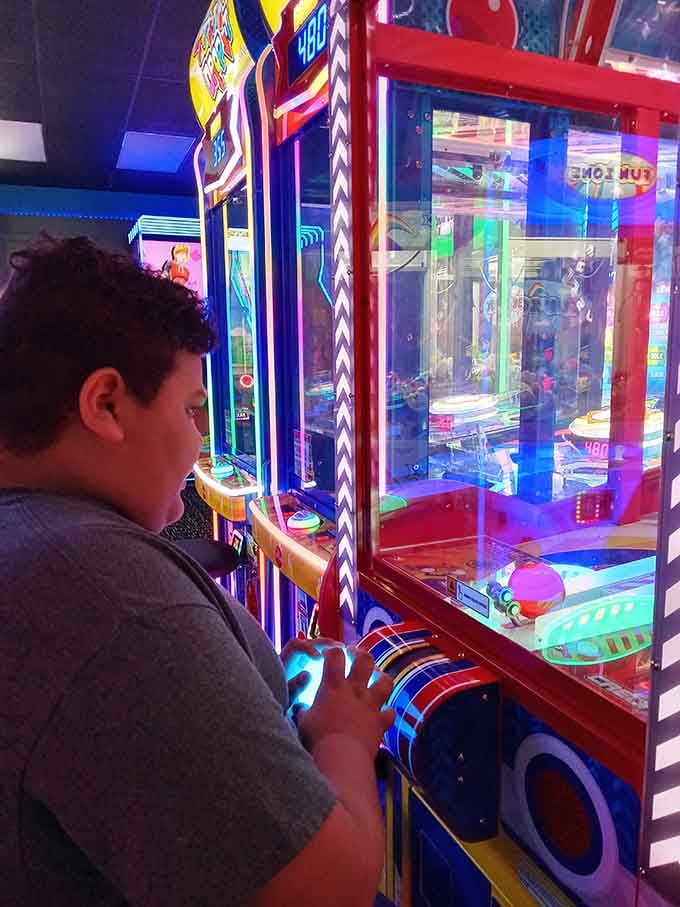 The concentration on his face suggests he's defusing a bomb rather than trying to win a rubber bracelet.