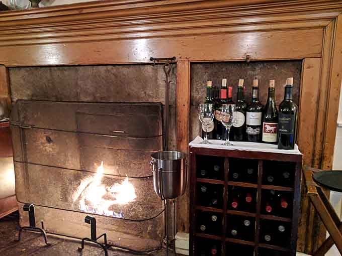 A crackling fireplace flanked by wine bottles creates the coziest corner for sipping reds on chilly New England evenings.