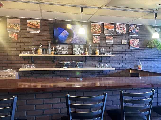 The sleek counter seating with exposed brick and trophy displays invites you to watch the pizza magic happen.