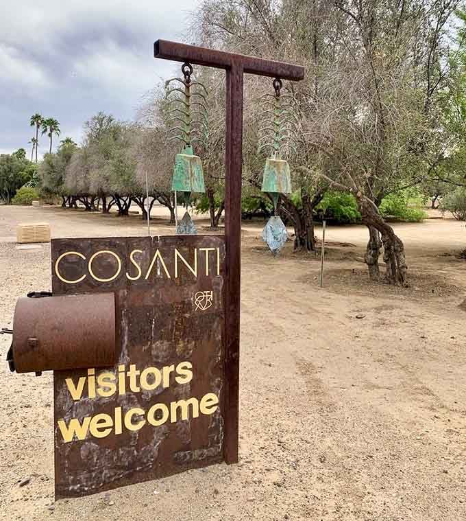 That weathered welcome sign perfectly captures the artistic spirit waiting just beyond those desert trees ahead.