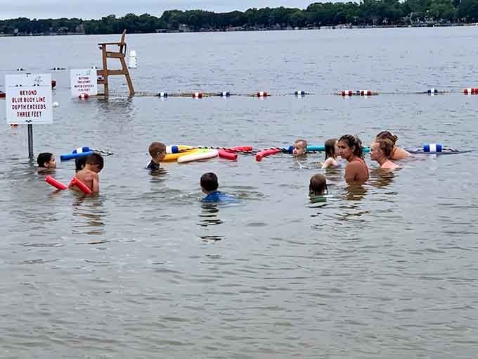 Swimmers of all ages share the roped-off area, creating that democratic beach culture where everyone's equally sunburned.