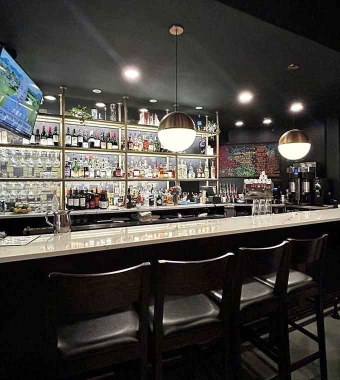 A well-stocked bar gleaming under pendant lights, ready to craft whatever your heart desires today.