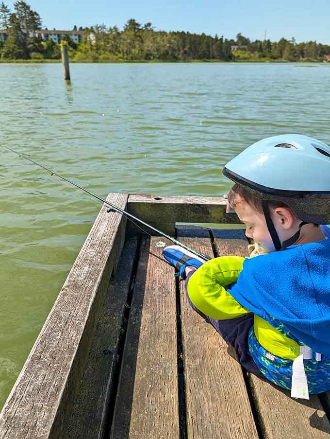 A young angler tries their luck from the dock, learning the ancient art of patience while hopefully catching dinner too.