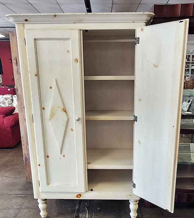 A vintage white cabinet with diamond details, perfect for storing linens or displaying your grandmother's china.