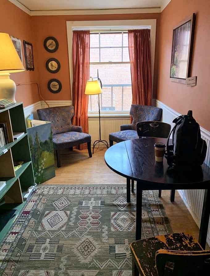 Warm peach walls and comfortable chairs create a living room atmosphere that beats your actual living room.