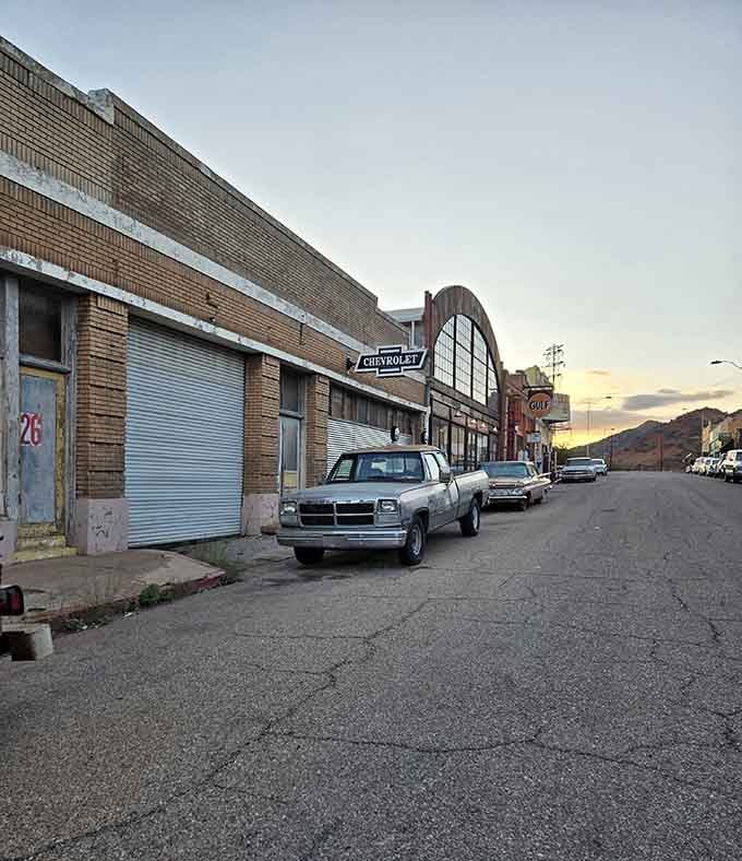 The Chevrolet sign arches overhead while vintage trucks rest below, creating a sunset scene Norman Rockwell would've painted twice.