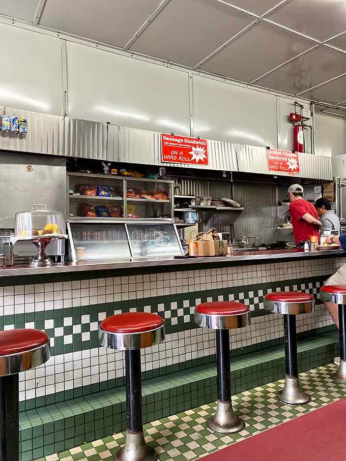 That checkered tile counter and chrome stools look like they've witnessed more happy meals than a thousand Instagram-worthy restaurants combined.