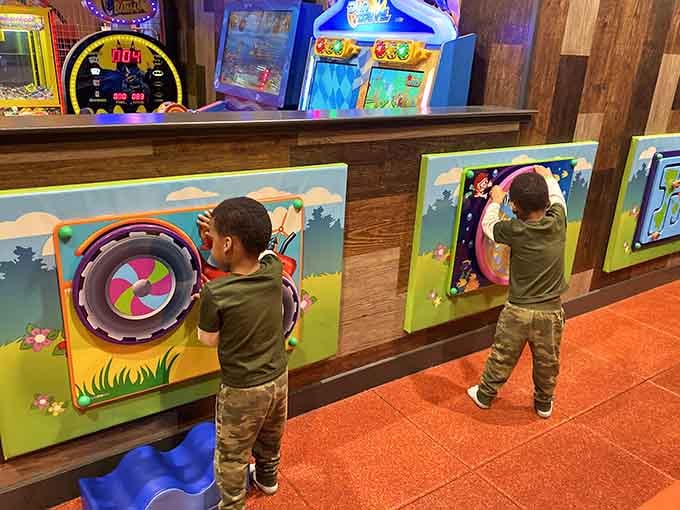 Toddlers at interactive wall games, proving that simple pleasures still work wonders in our digital age.