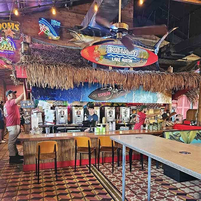 That thatched-roof bar with hanging surfboards is where tropical drinks and good decisions go to party together.