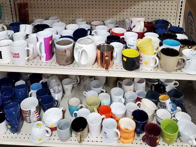 Coffee mugs in every color and style, because apparently we all donate our impulse purchases from gift shops.