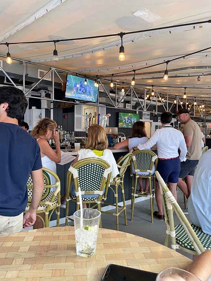 The outdoor bar buzzes with energy as patrons gather under string lights, creating that perfect vacation vibe year-round.