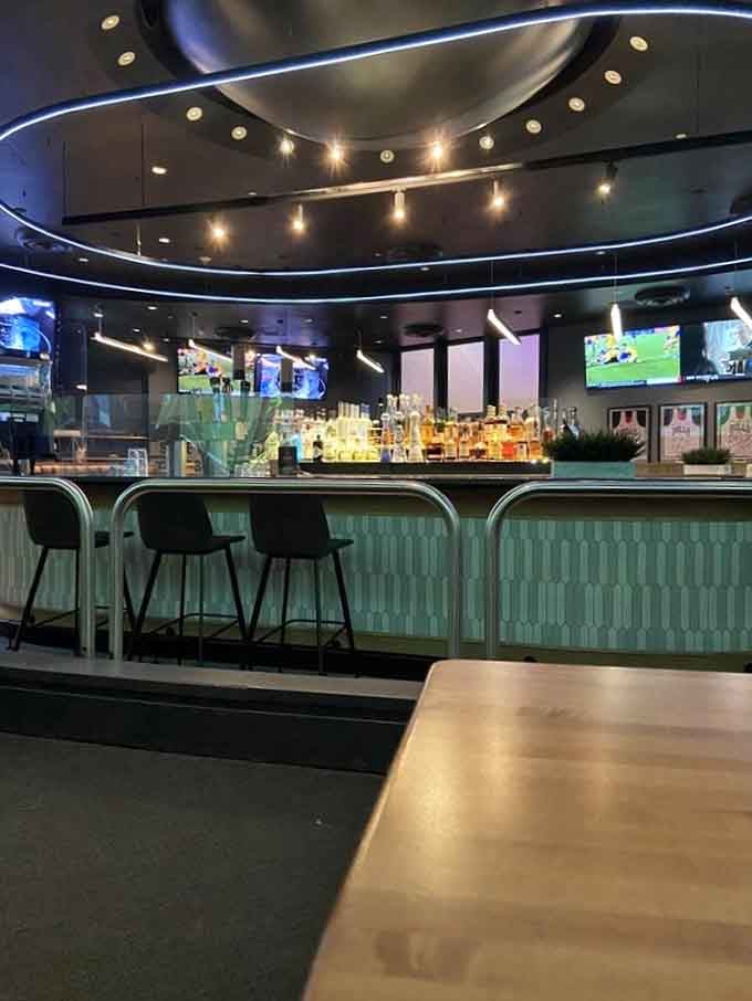 The bar stretches invitingly with top-shelf bottles gleaming under modern lighting, while screens ensure you never miss a crucial play or replay.