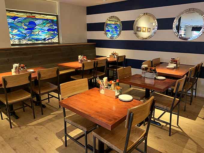 Porthole mirrors and nautical stripes create coastal vibes without veering into tacky souvenir shop territory, thankfully.