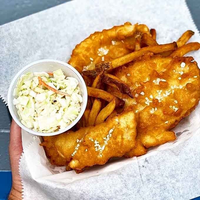 Halibut fried to perfection with coleslaw and fries proves that simple preparations let quality ingredients truly shine through.